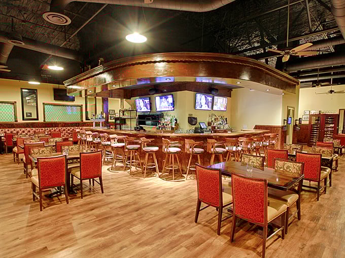 The gleaming wooden bar curves invitingly through the dining room, promising perfectly mixed manhattans and bourbon neat while red upholstery adds a touch of old-school steakhouse glamour.