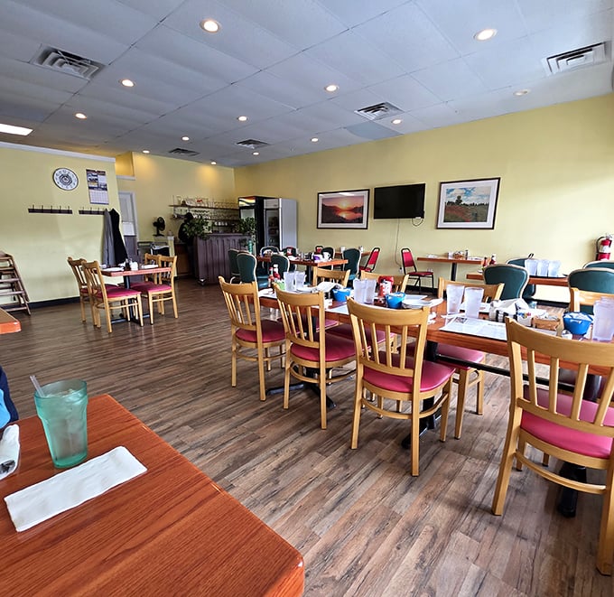Yellow walls and wooden chairs create the perfect canvas for breakfast artistry. This dining room isn't trying to impress you—until the food arrives.