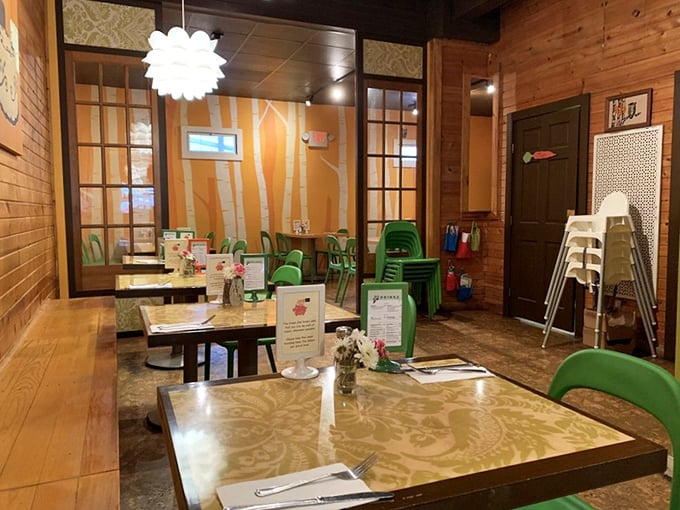 Warm wooden walls meet playful green chairs in a dining room that feels like your coolest friend's living room—if that friend were a culinary genius.