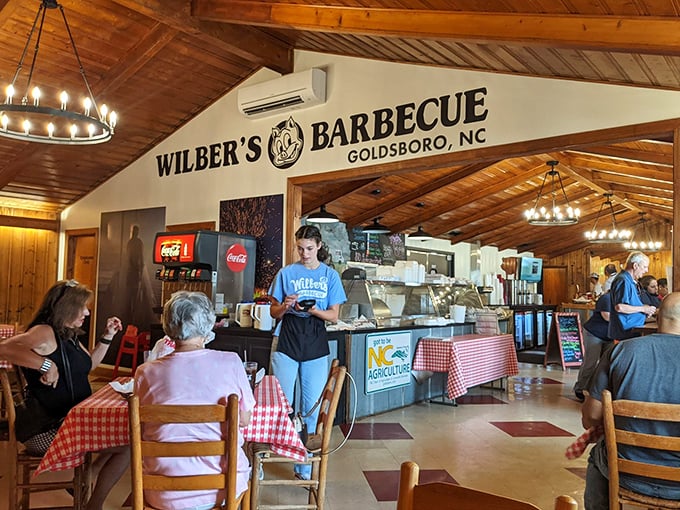 Wooden beams, circular chandeliers, and checkered tablecloths—the holy trinity of authentic barbecue ambiance. Time stands deliciously still at Wilber's.