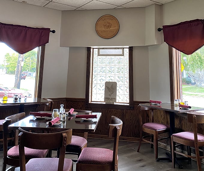 Warm wood paneling and burgundy accents create that "Nonna's dining room" vibe—minus the plastic-covered furniture.