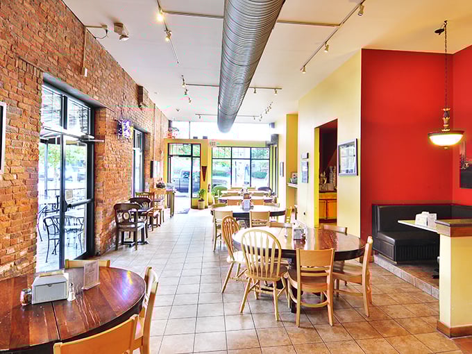 Exposed brick walls meet warm lighting in this inviting dining space, where every table offers a front-row seat to wood-fired magic.