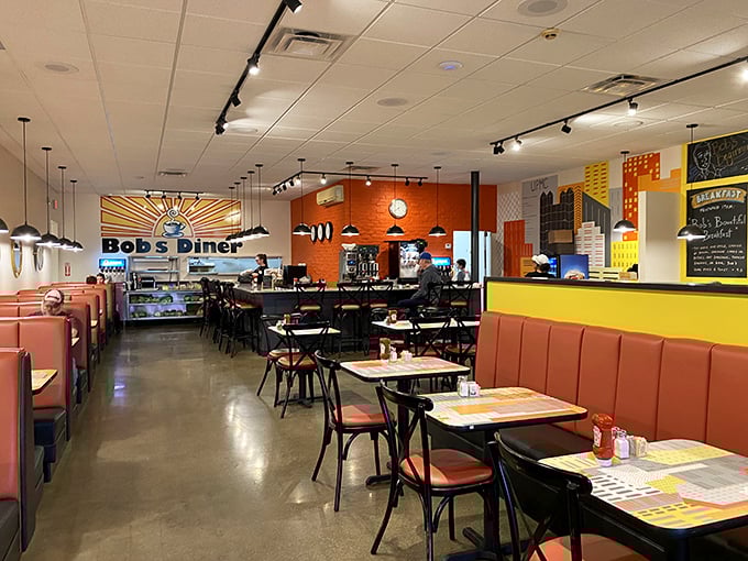 Sunshine-bright orange booths and modern industrial touches create the perfect backdrop for the morning ritual of coffee and conversation.