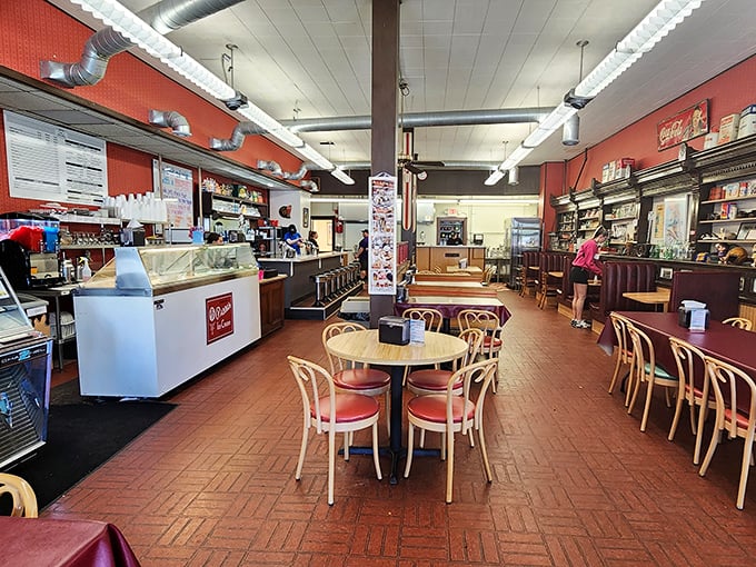 Step inside and the 1950s greet you with open arms. Red brick floors, wooden tables, and that soda counter promising sweet relief from modern chaos. 