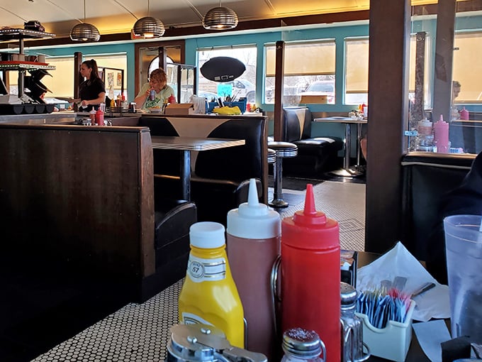 Inside, the quintessential diner experience awaits with pendant lights casting a warm glow over booths where breakfast dreams come true.