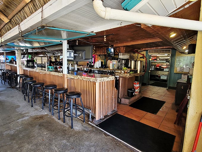 The tiki bar beckons with bamboo accents and weathered charm—a place where your beer stays cold and your worries stay outside.