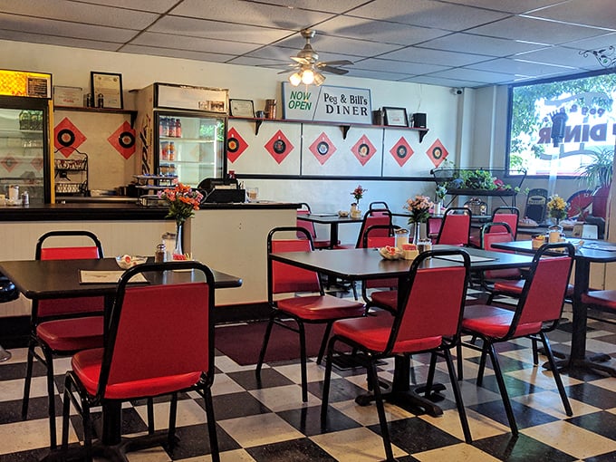 Classic diner aesthetics at their finest—red vinyl chairs, checkered floors, and that unmistakable counter where breakfast dreams come true.