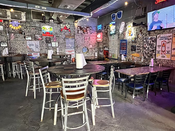 Dollar bills wallpaper the interior like a scrapbook of satisfied customers. Each table tells a story of memorable meals shared beneath the glow of neon beer signs.
