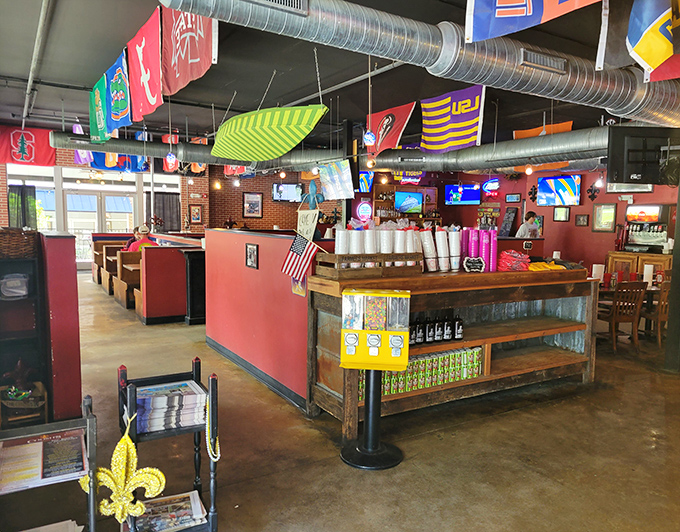College pennants dance overhead while exposed ductwork meets warm red walls—a dining room where Louisiana spirit meets Florida hospitality.