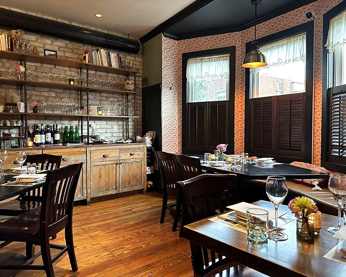Vintage floral wallpaper meets exposed brick in this cozy dining room. It's like your stylish Italian aunt finally got the renovation budget she deserved.