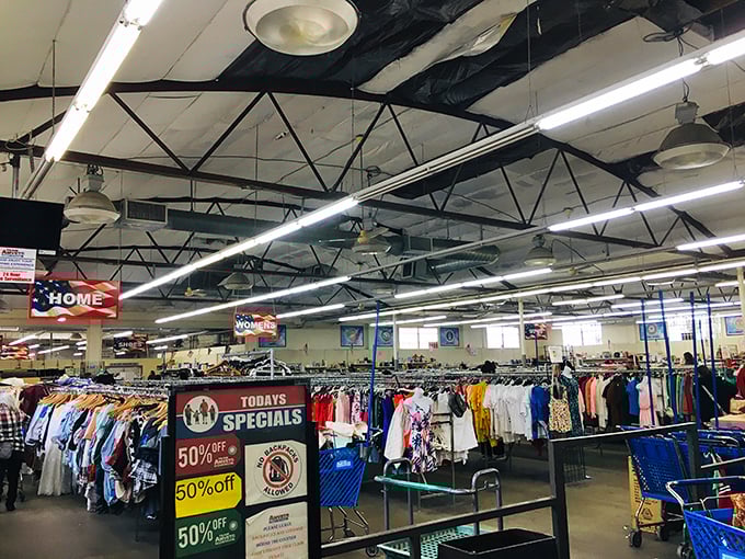 Beneath industrial ceilings, a sea of clothing racks stretches toward the horizon—color-coded sections creating a roadmap for retail adventurers.