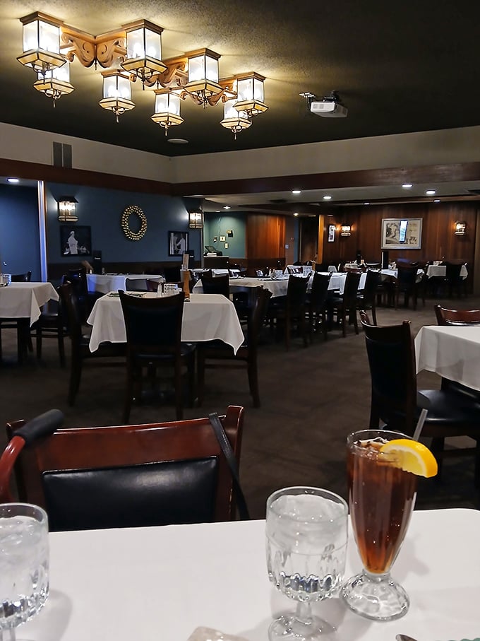 Elegant lighting fixtures cast a warm glow over crisp white tablecloths – dining ambiance that whispers "special occasion" without the pretension.