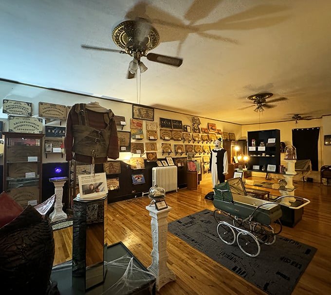Vintage Ouija boards line the walls while an antique baby carriage sits ominously in the center—nursery rhymes not included.