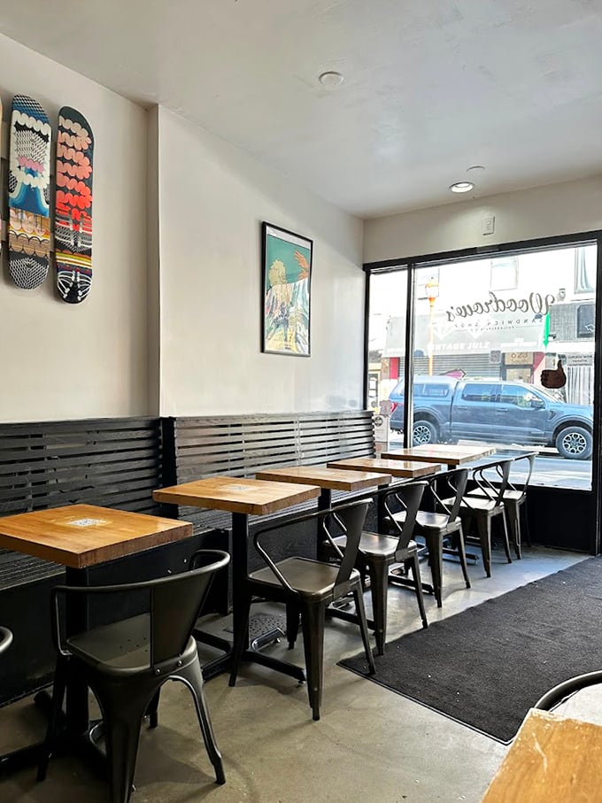 Minimalist chic meets sandwich artistry. The clean lines, wooden tables, and skateboard art create the perfect backdrop for the main event: your next favorite meal.