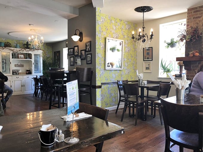 Vintage chandeliers, yellow floral wallpaper, and exposed brick create that rare atmosphere that's both sophisticated and cozy—like your stylish friend's dining room.
