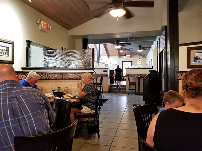 Inside Guppy's, wooden ceiling beams and comfortable seating create that perfect "upscale casual" vibe where both flip-flops and fancy shoes feel equally at home.