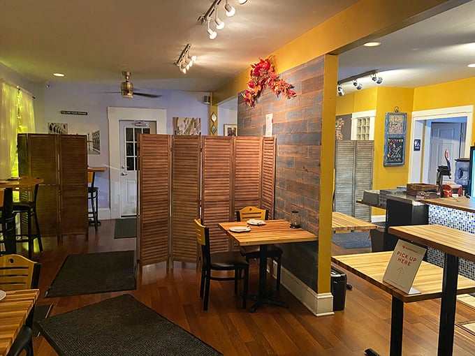 Wooden dividers and warm yellow walls create intimate dining nooks that make every table feel like the best seat in the house.