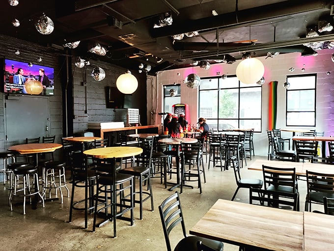 Industrial chic meets neighborhood comfort inside Slammers, where disco balls cast playful light patterns across concrete floors and wooden tables.