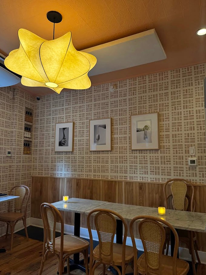 The star-shaped pendant light casts a warm glow over cane-backed chairs and patterned walls, creating that "I've discovered somewhere special" feeling.