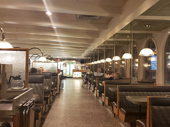 Classic diner ambiance with a touch of elegance – pendant lights cast a warm glow over booths where countless conversations and comfort food memories have been made.