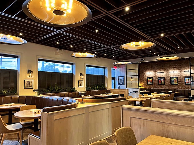 The sleek interior balances modern elegance with cozy comfort – those golden disc lights are basically halos for your pasta.