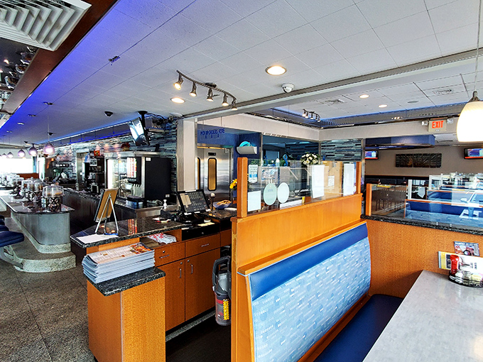 Step inside and breathe in that unmistakable diner aroma – coffee brewing, bacon sizzling, and conversations flowing across the classic blue and orange interior.