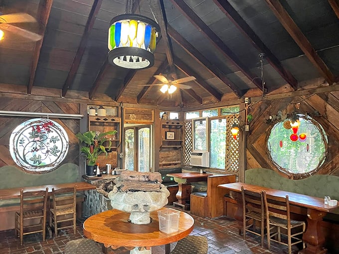 Step inside and time slows down – circular stained glass windows cast kaleidoscope patterns across rustic wooden tables in this magical dining space.