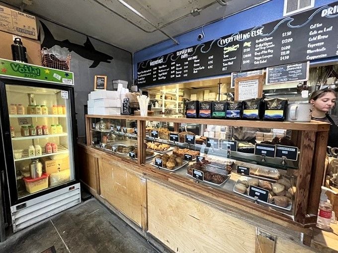 Behind this unassuming wooden counter lies a world of baked wonders, where the shark logo watches over pastry perfection.