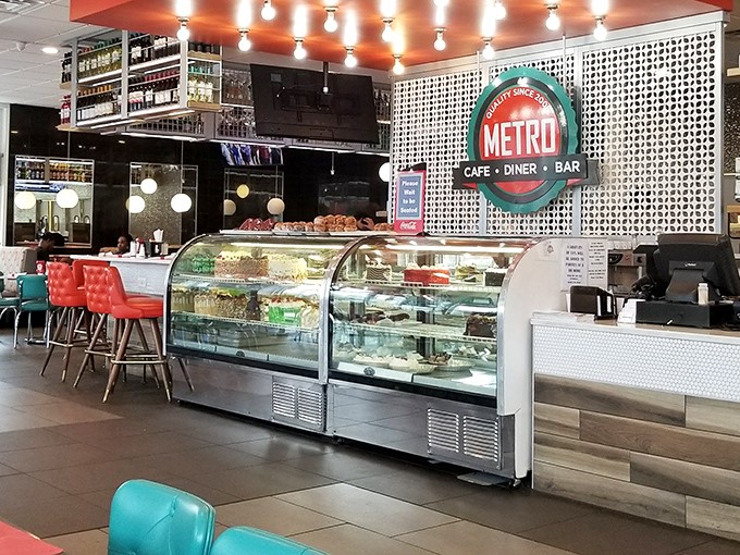 Inside, the dessert case stands like the Louvre of layered sweets, while turquoise and red seating pops against modern decor—diner DNA with contemporary chromosomes.