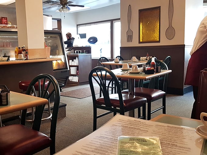 Classic diner aesthetics with those burgundy chairs and simple decor – like stepping into a breakfast time machine where the food matters more than the furniture.