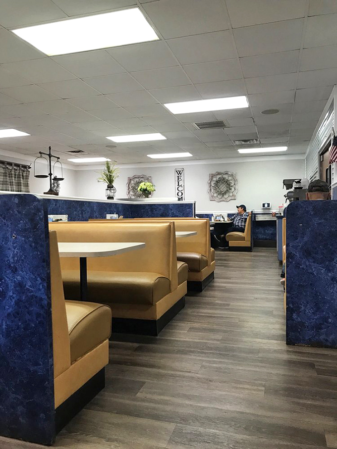 Classic diner comfort with blue dividers and tan booths. This isn't designer décor—it's the authentic stage where breakfast dreams come true.