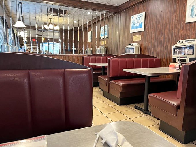 Classic burgundy booths invite you to slide in and stay awhile. Wood paneling and cozy seating—diner design that's stood the test of time.