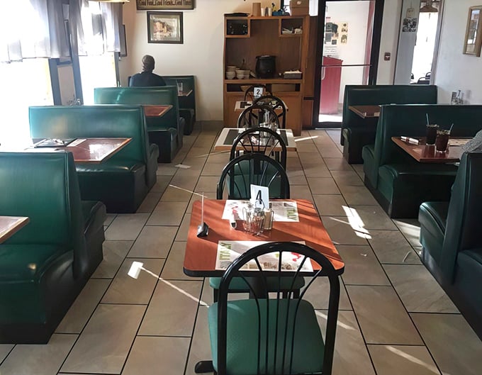 Classic green booths and simple tables create that perfect "neighborhood Italian joint" atmosphere where comfort trumps pretension every time.