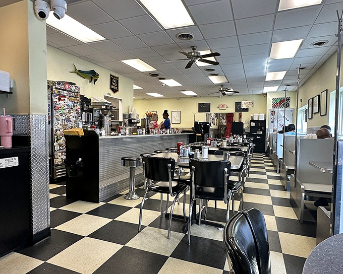 Classic black and white checkered floors set the stage for breakfast theater, where chrome accents and counter seating create the quintessential American diner experience.
