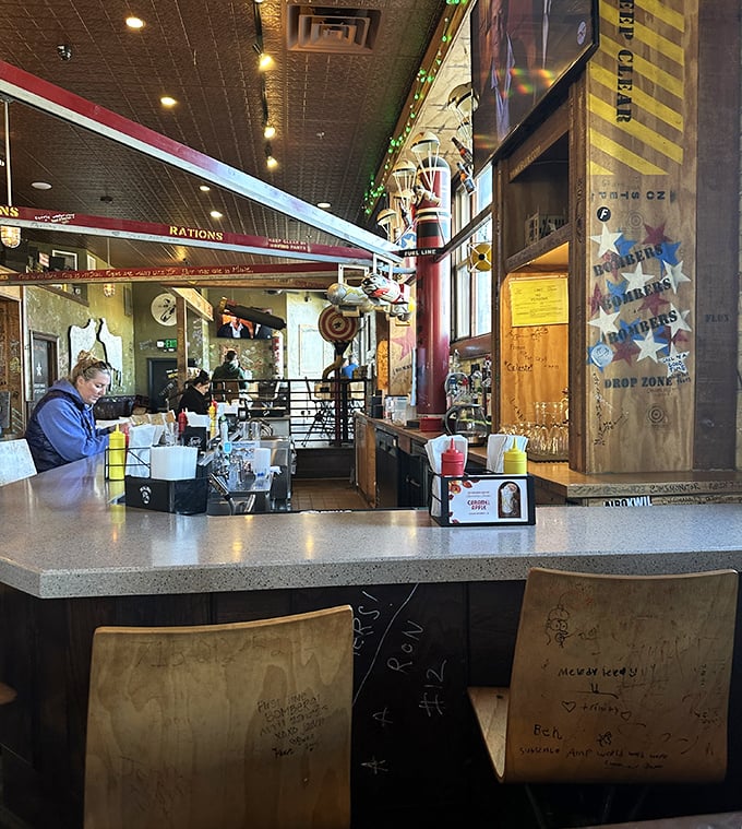 Inside, aviation-themed whimsy meets burger joint practicality. Those tracks on the ceiling? They're not just decoration—they're peanut delivery systems!