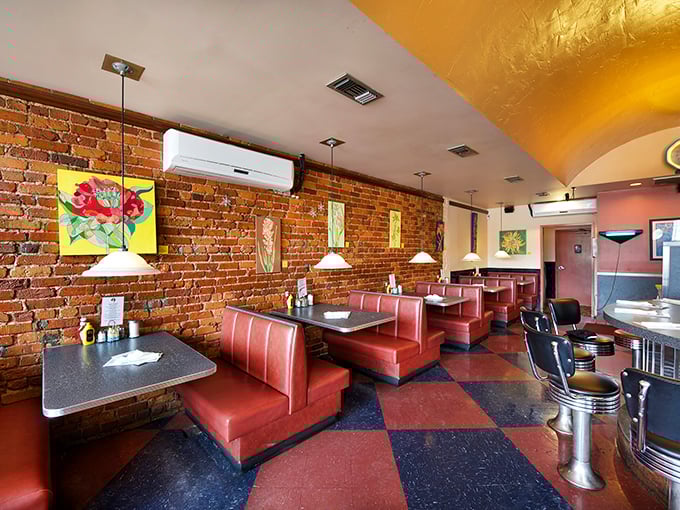 Classic red vinyl booths against exposed brick walls create that perfect diner atmosphere where comfort food and comfort seating go hand in hand.