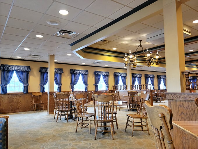 Blue curtains frame windows like a grandmother's dining room. Wooden chairs and warm lighting create that "come sit a spell" atmosphere that chain restaurants try desperately to fake.