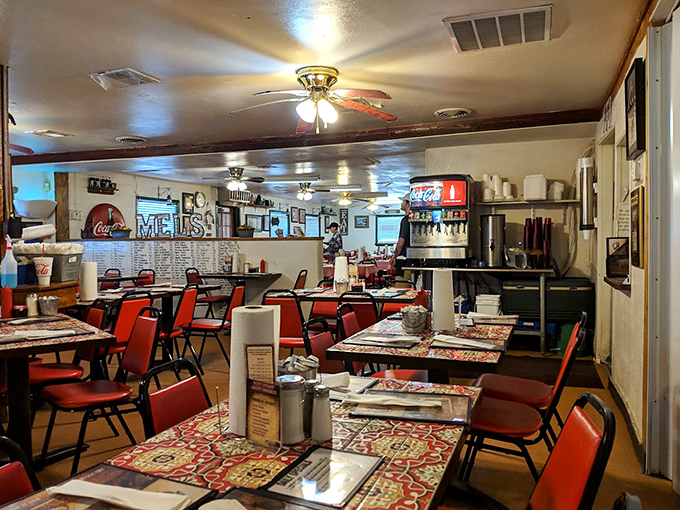 Red chairs, ceiling fans, and patterned tablecloths create the perfect backdrop for comfort food conversations. No Edison bulbs needed.