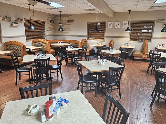 The dining room's warm wood tones and comfortable booths invite you to settle in. Notice the pendant lights – not trying to be trendy, just doing their job illuminating countless happy meals.