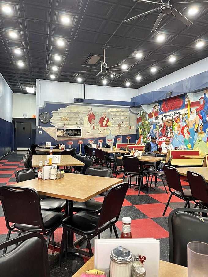 Classic black and red checkered floors, colorful murals, and no-nonsense tables create that perfect diner atmosphere where memories are made one meal at a time.