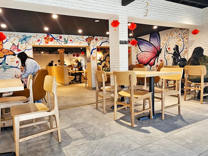 Whimsical butterflies and dreamy murals transform a simple dining space into something magical—like Willy Wonka designed an Asian bakery.