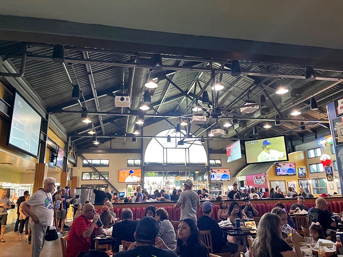 The bustling interior buzzes with energy as diners gather under exposed beams, where sports on TV and sizzling grills create the perfect symphony.