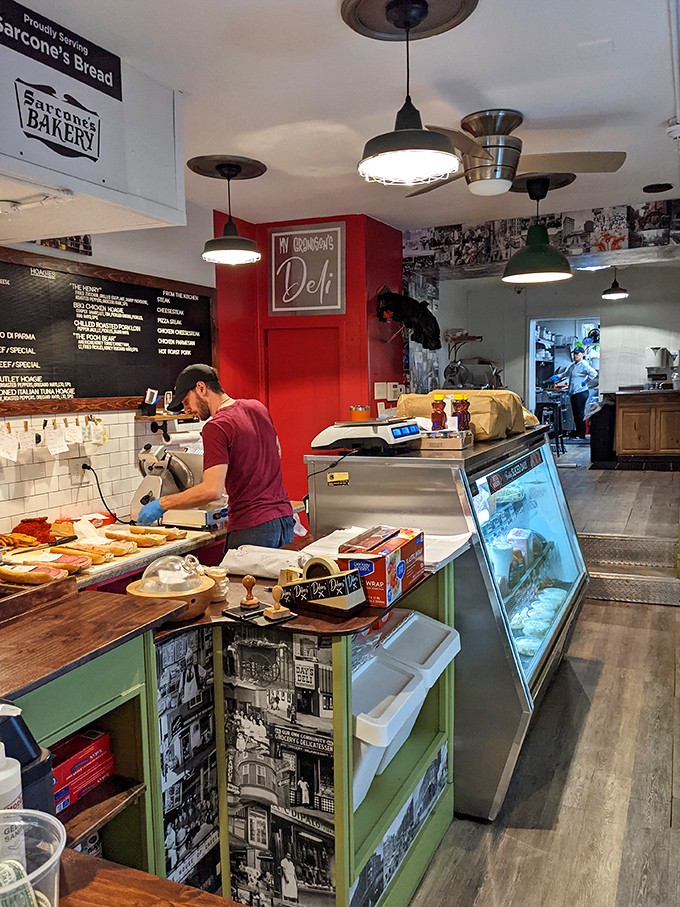 Where sandwich artistry happens. The red accent wall and vintage Philly photos aren't just decor – they're a visual appetizer before the main event.