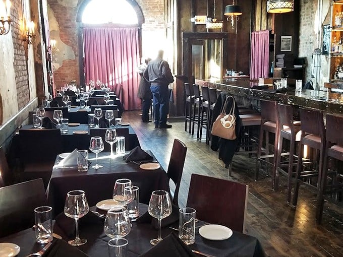Step inside to discover the perfect marriage of rustic charm and elegant dining—exposed brick walls, pink curtains, and tables set for memorable meals.