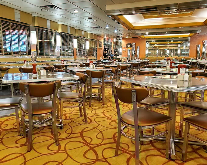 Inside, a symphony of chrome, warm lighting, and patterned carpeting creates the perfect backdrop for conversations that flow as freely as the coffee.