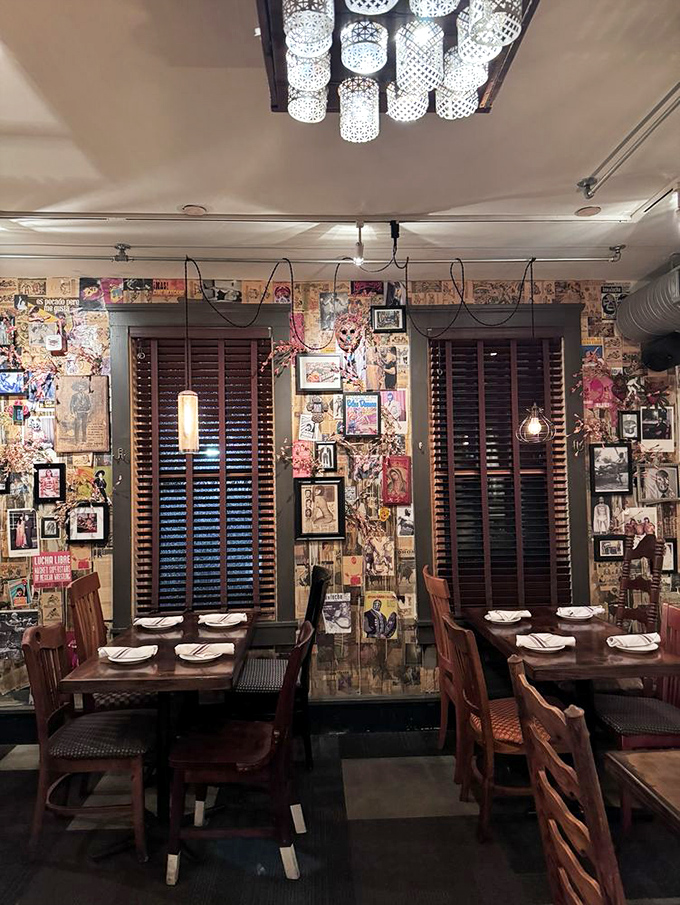 Collage-covered walls tell visual stories while pendant lights cast a warm glow—dining room décor that's equal parts art gallery and cozy cantina.