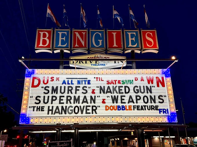 The marquee doesn't just announce movies—it broadcasts nostalgia in red, white, and blue neon. Cinema history illuminated against the night sky.
