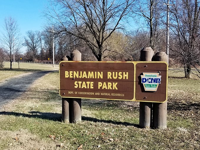The unassuming entrance sign belies the natural wonderland waiting beyond – Philadelphia's only state park welcomes explorers.