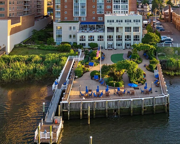 Riverside relaxation at its finest—blue umbrellas, manicured gardens, and waterfront views create an urban oasis where stress simply floats away.