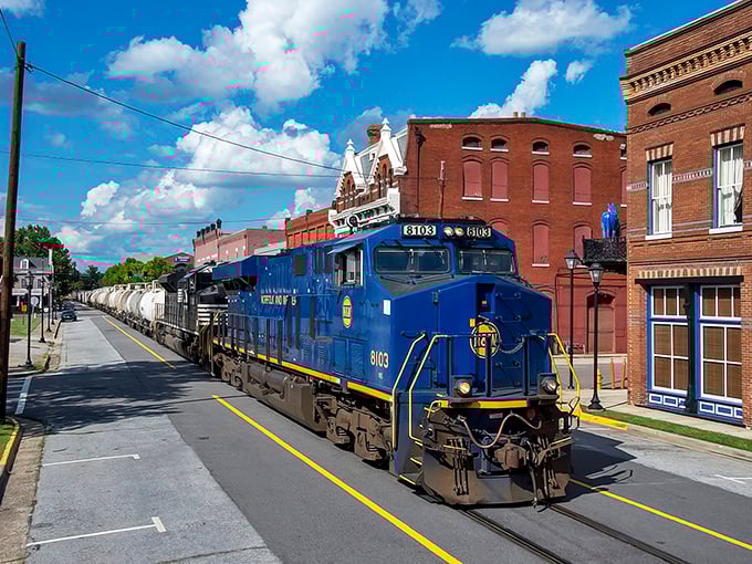 A blue locomotive chugs through downtown Augusta, where affordable living meets small-town charm along historic brick-lined streets.